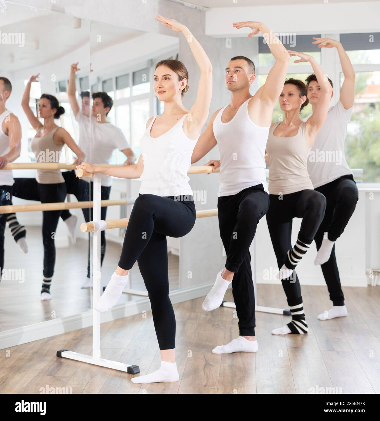 Group of dancers practicing at ballet barre Stock Photo - Alamy