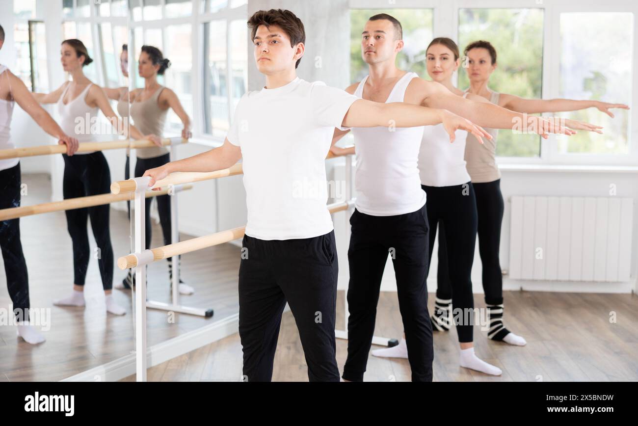 Group of dancers stand in second position at barre Stock Photo - Alamy