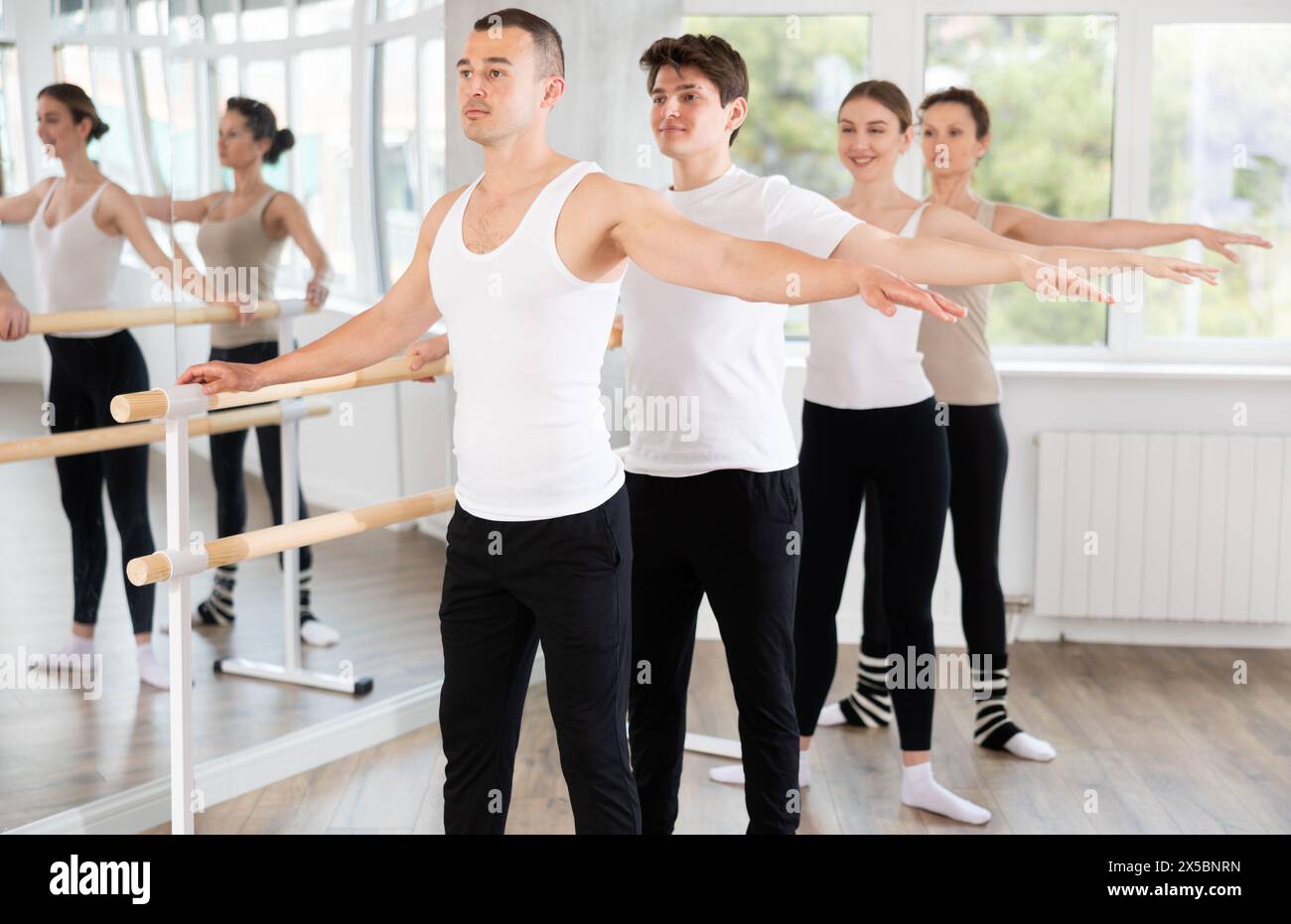 Group of dancers stand in second position at barre Stock Photo - Alamy
