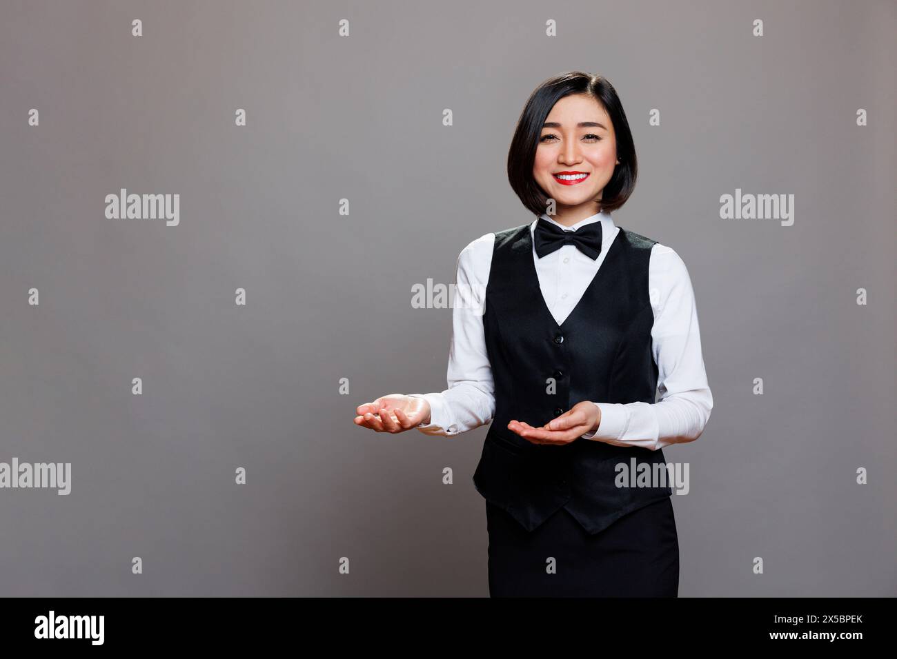 Smiling asian woman restaurant receptionist welcoming guests and ...