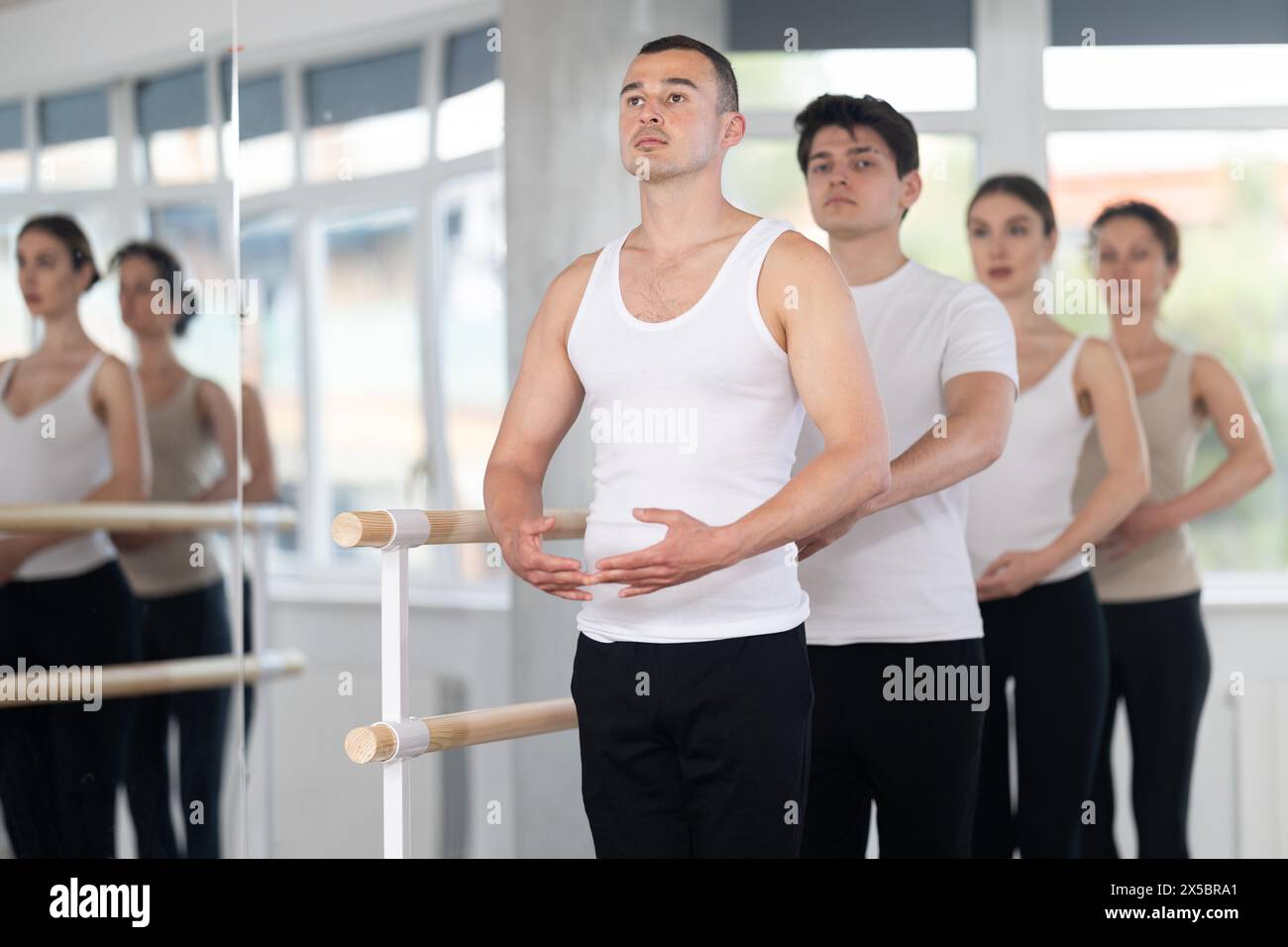Group of dancers stand in first position at barre Stock Photo - Alamy