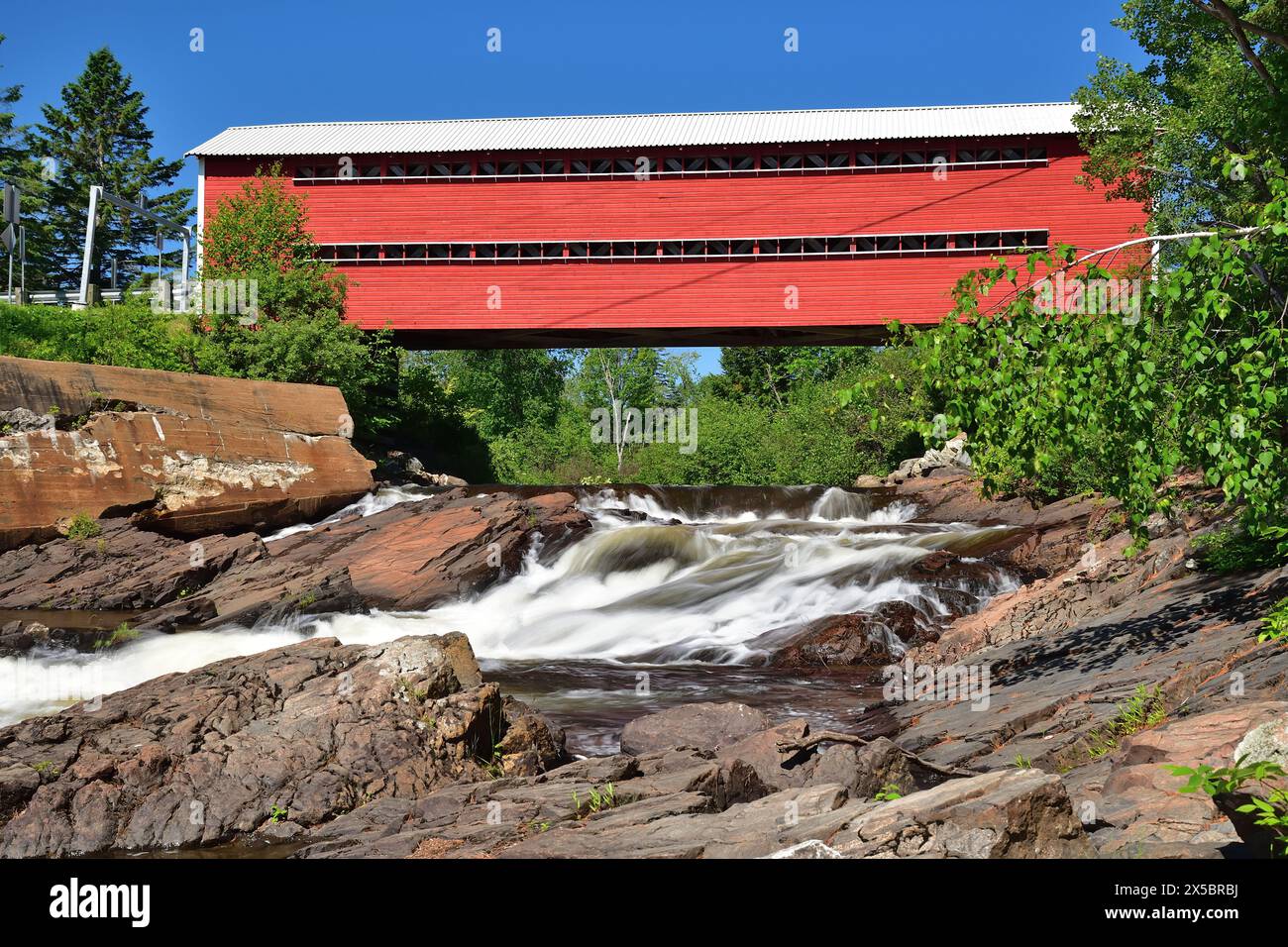 Covered bridge over a fast moving water stream. Long exposure effect ...