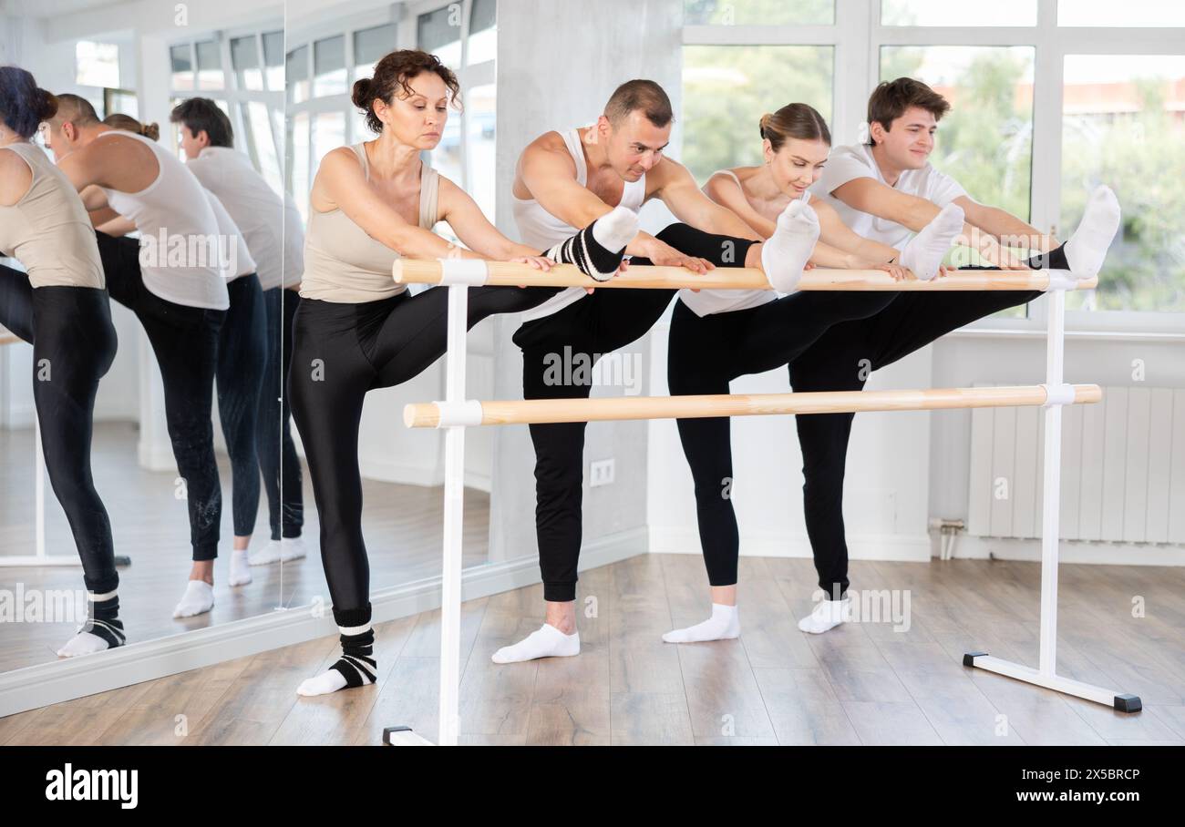 Group of dancers doing stretching at barre Stock Photo - Alamy