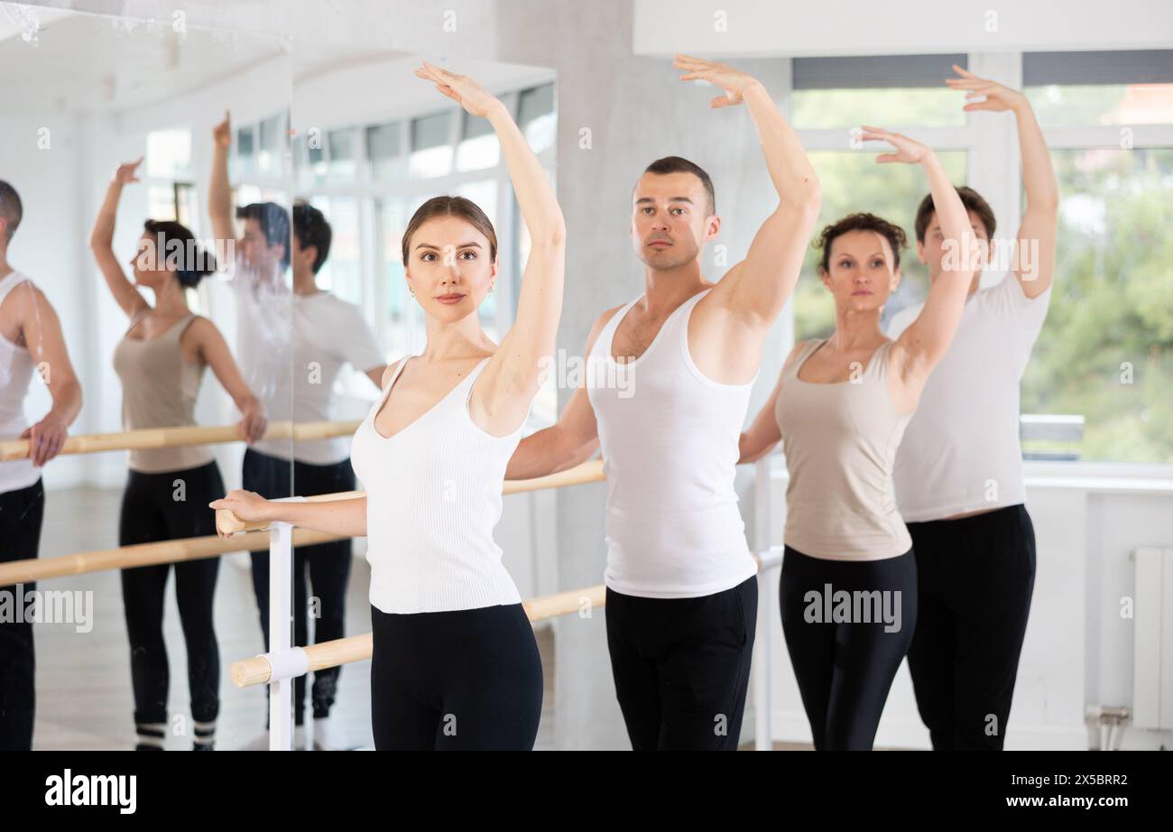 Group of positive young women and men engaged in classical ballet in ...
