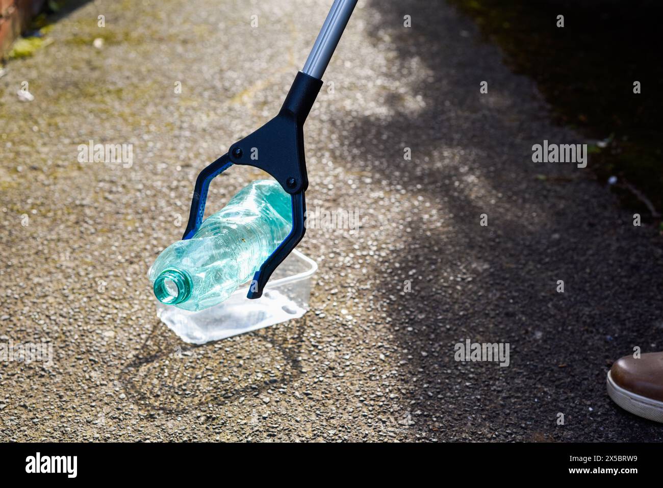 Picking up plastic waste and rubbish which has been dropped on the ...