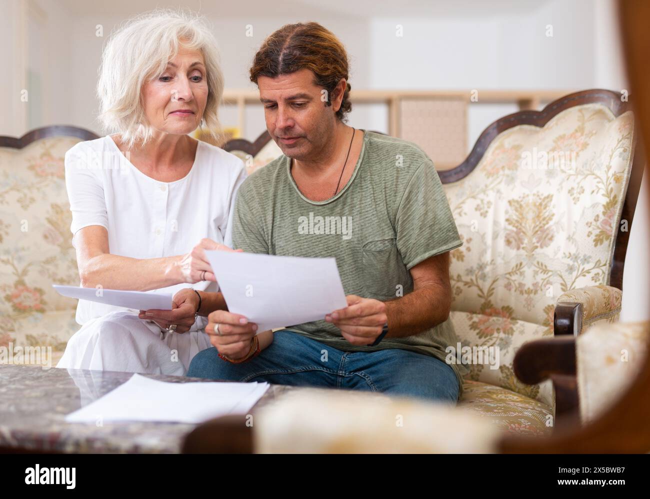 Helpful man helping elderly woman to sign documents Stock Photo - Alamy