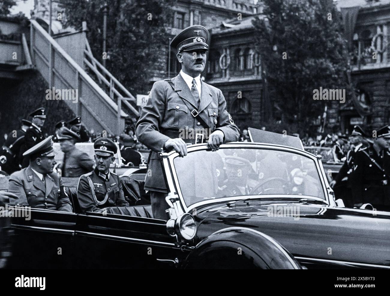 Adolf Hitler standing in his car as he travels through the ancient town ...