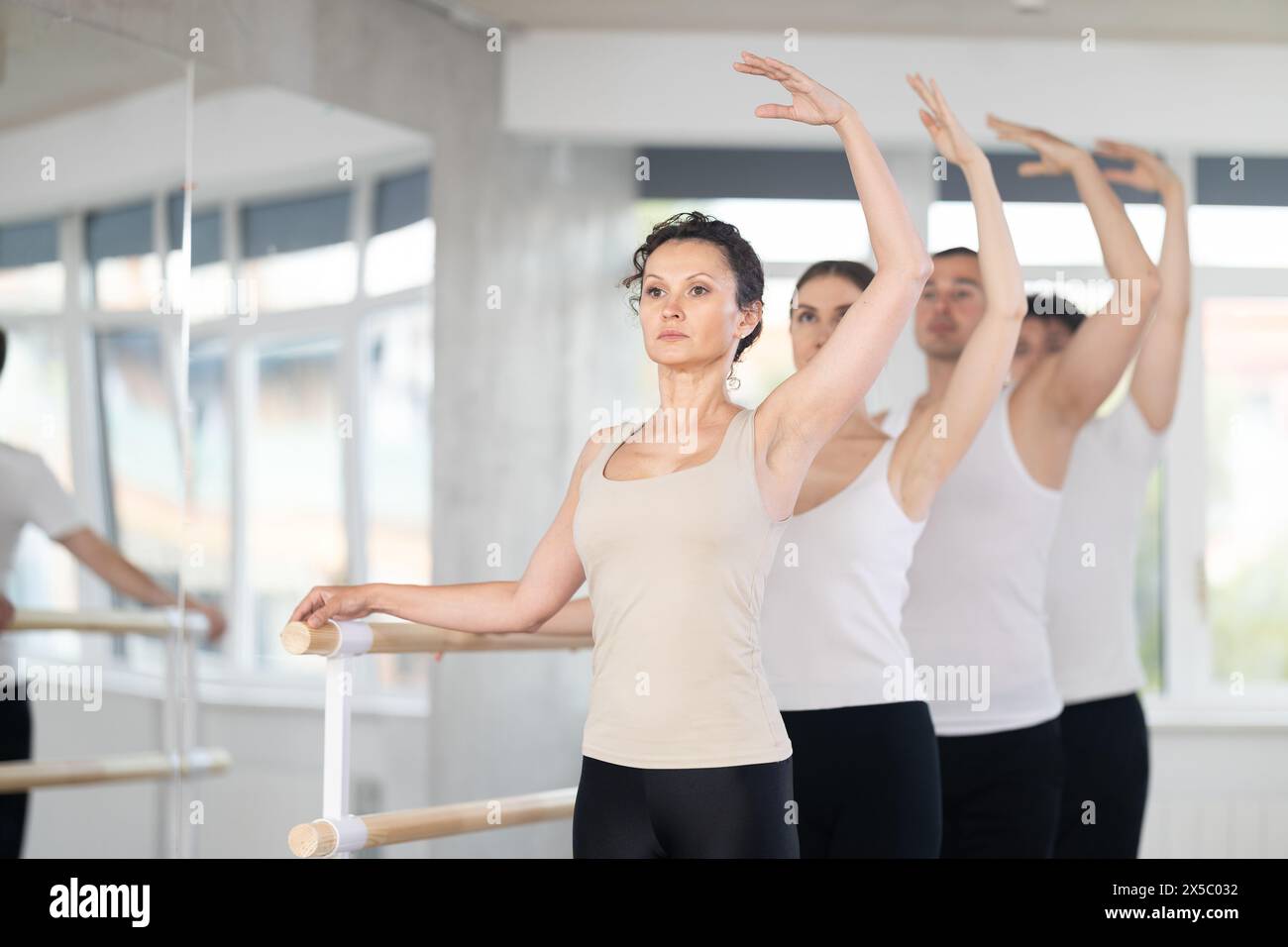 Group of dancers stand in third position at barre Stock Photo - Alamy