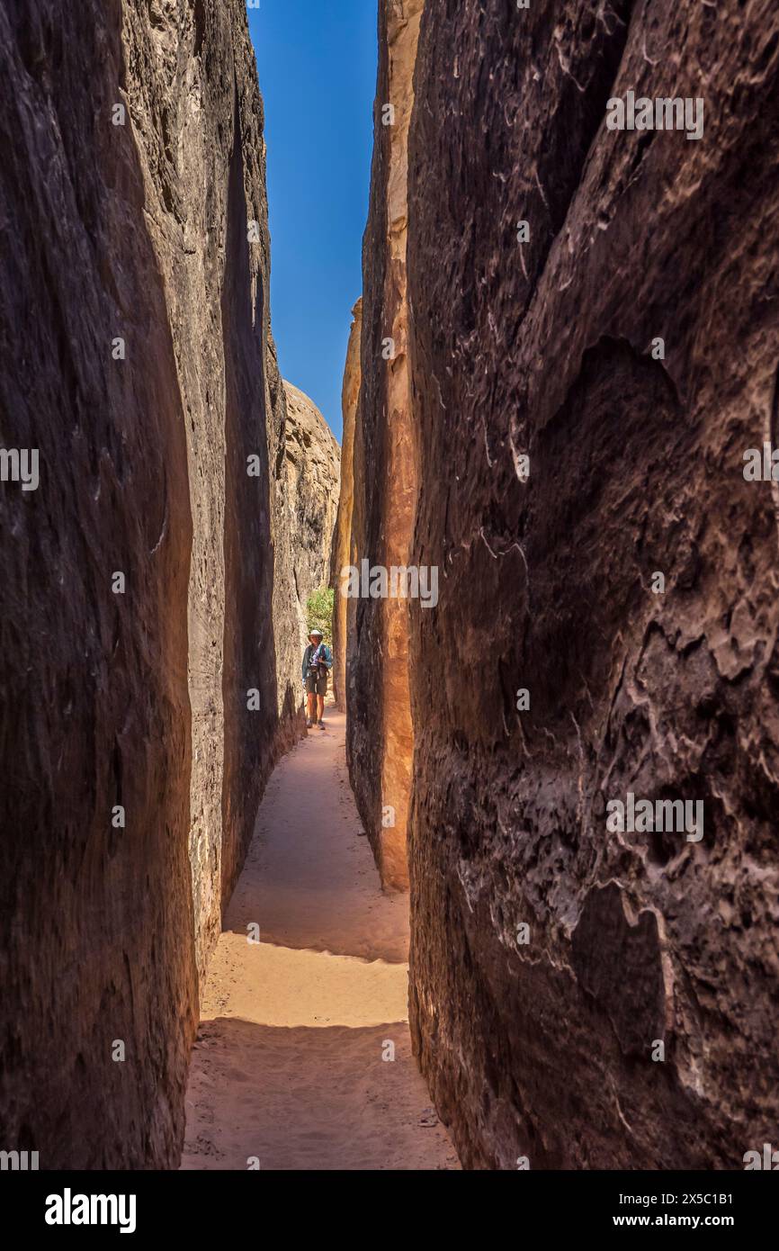 Woman walks through "the Joint," Joint Trail, Needles District ...