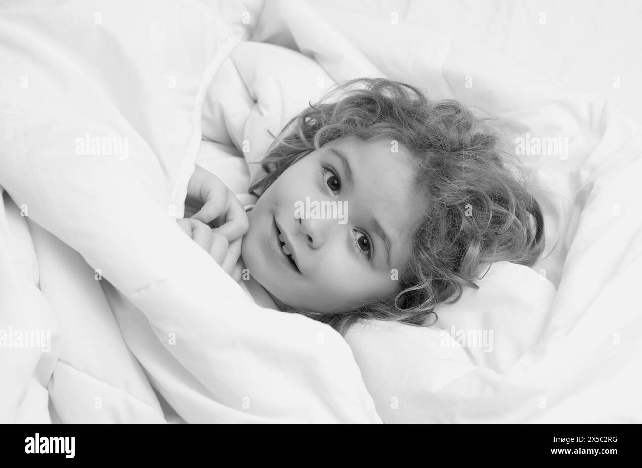 Cute awaking child in bed, bedtime, childhood and growth kids concept ...