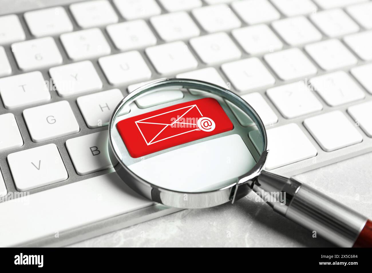 Red button with illustration of envelope and email sign on computer keyboard, view through ...