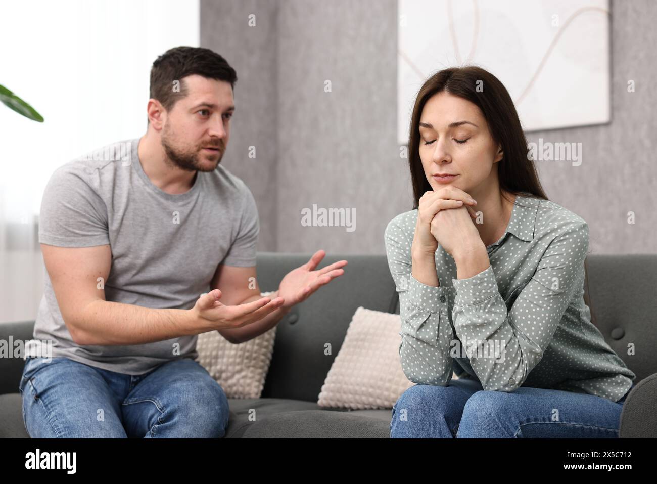 Offended wife ignoring her husband indoors. Relationship problems Stock ...