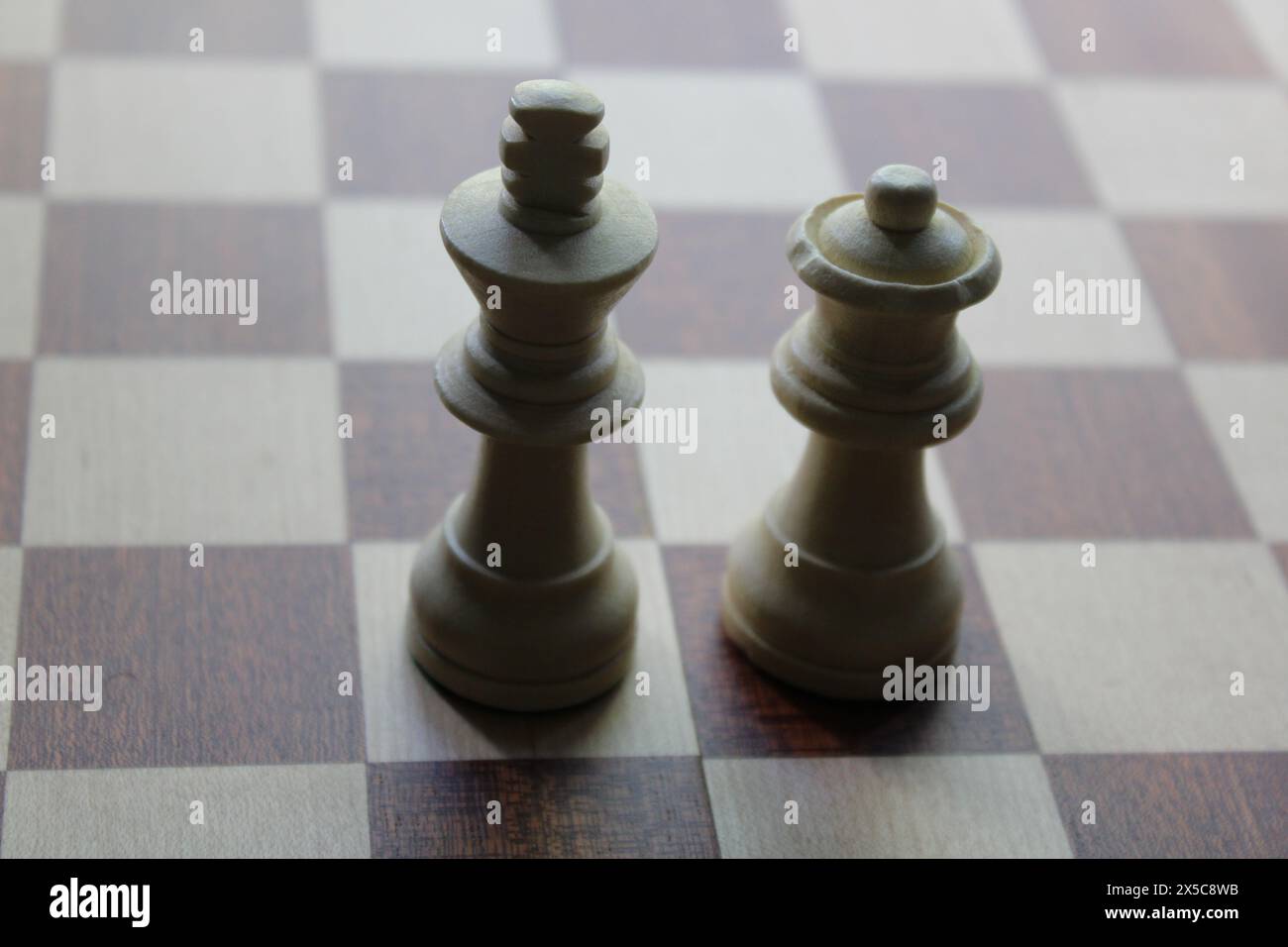 The white king and queen standing on a chessboard Stock Photo - Alamy