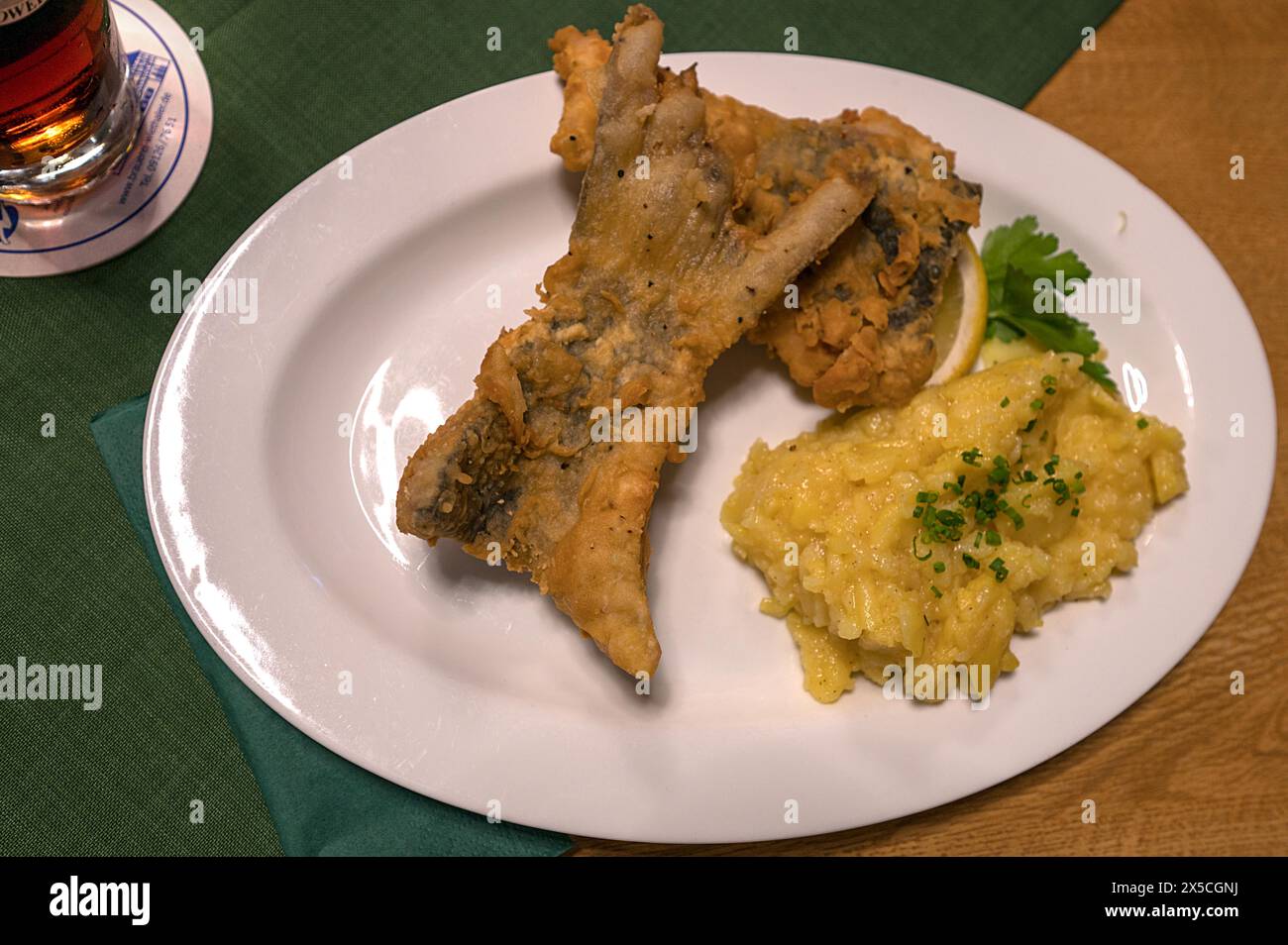 Baked carp fillet (Cyprinus carpio) served with potato salad in a pub ...
