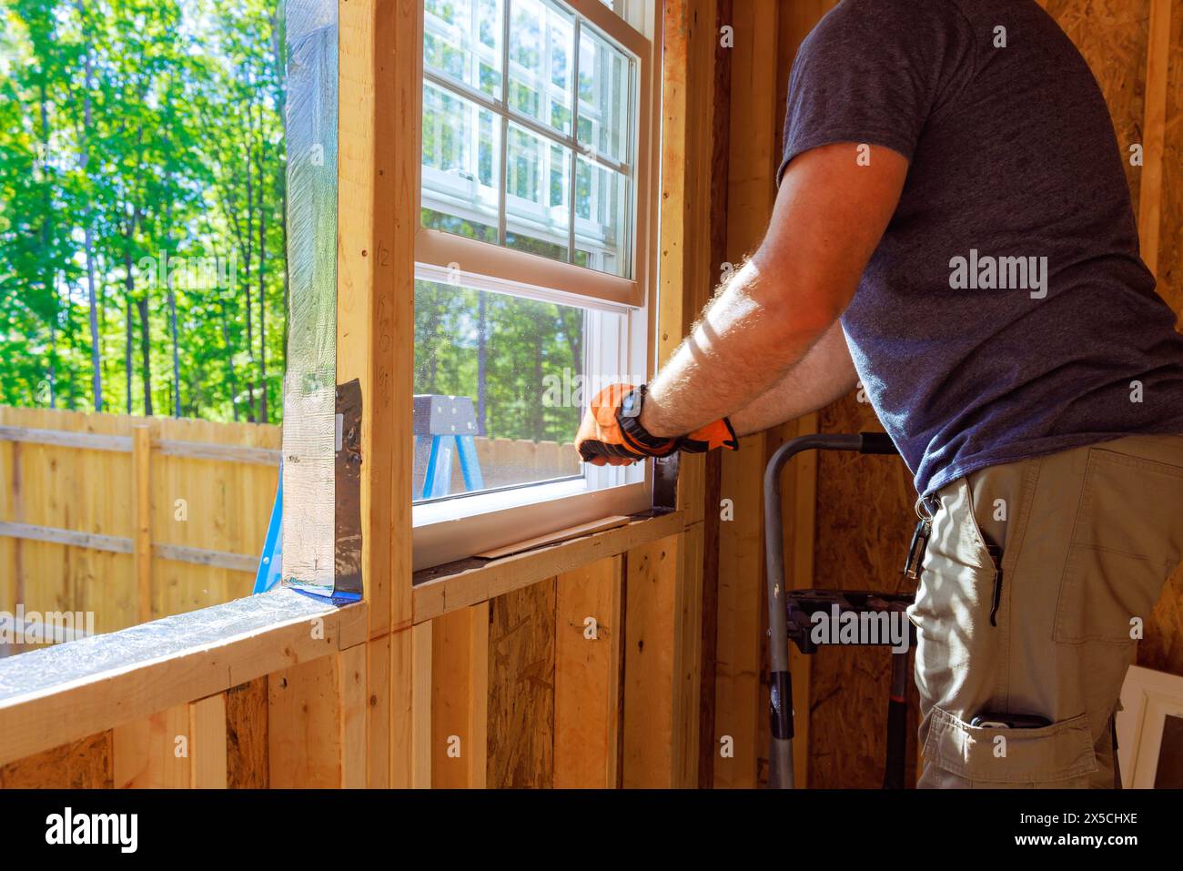 Installing plastic windows in new house by construction worker with ...