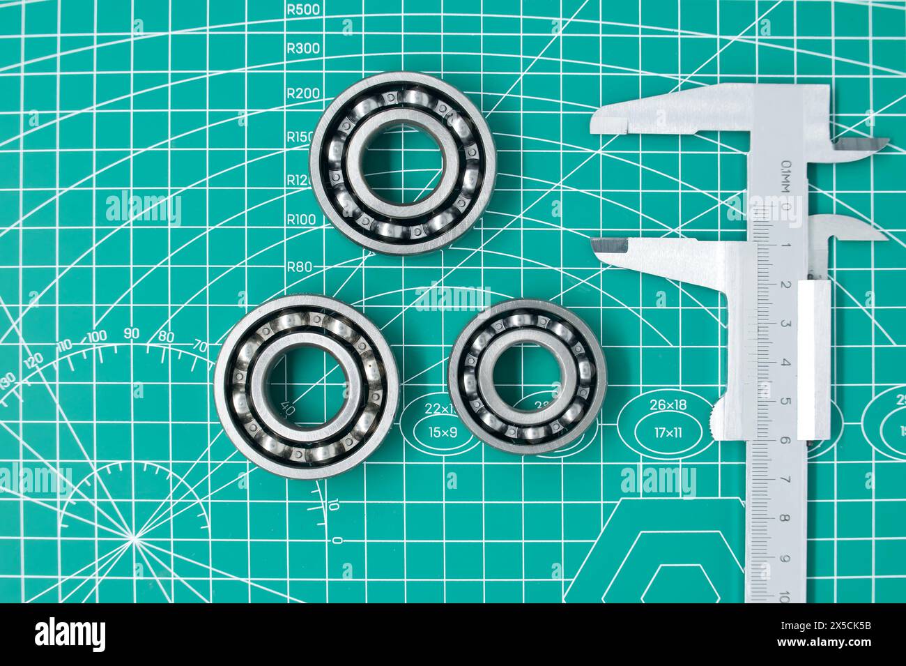Measure caliper and roller bearings on green cutting mat with free copy ...