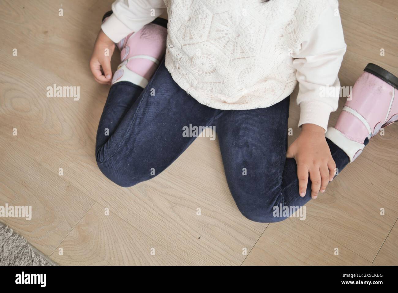 child sitting W posture on the floor Stock Photo - Alamy