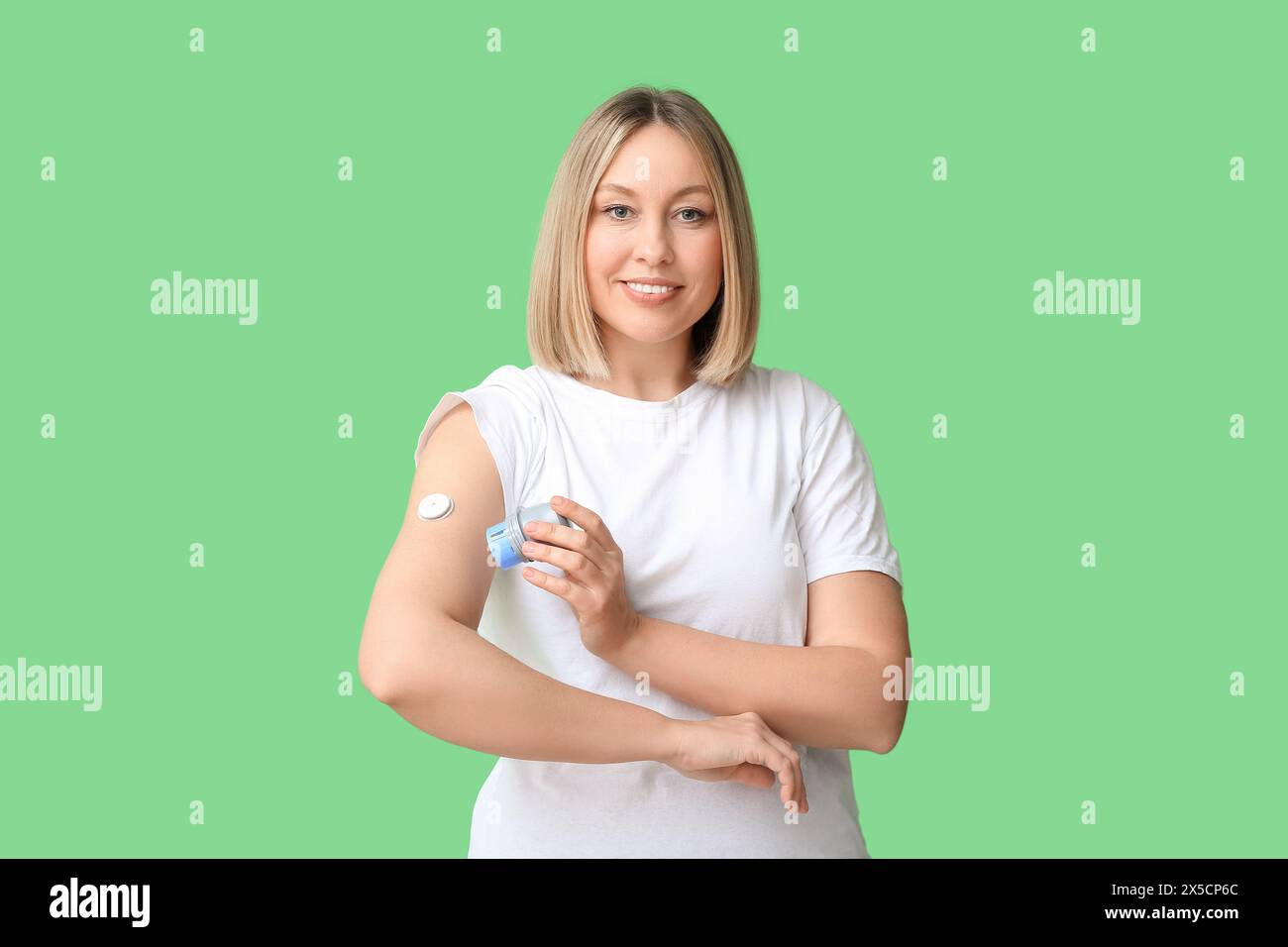 Woman with glucose sensor for measuring blood sugar level and ...