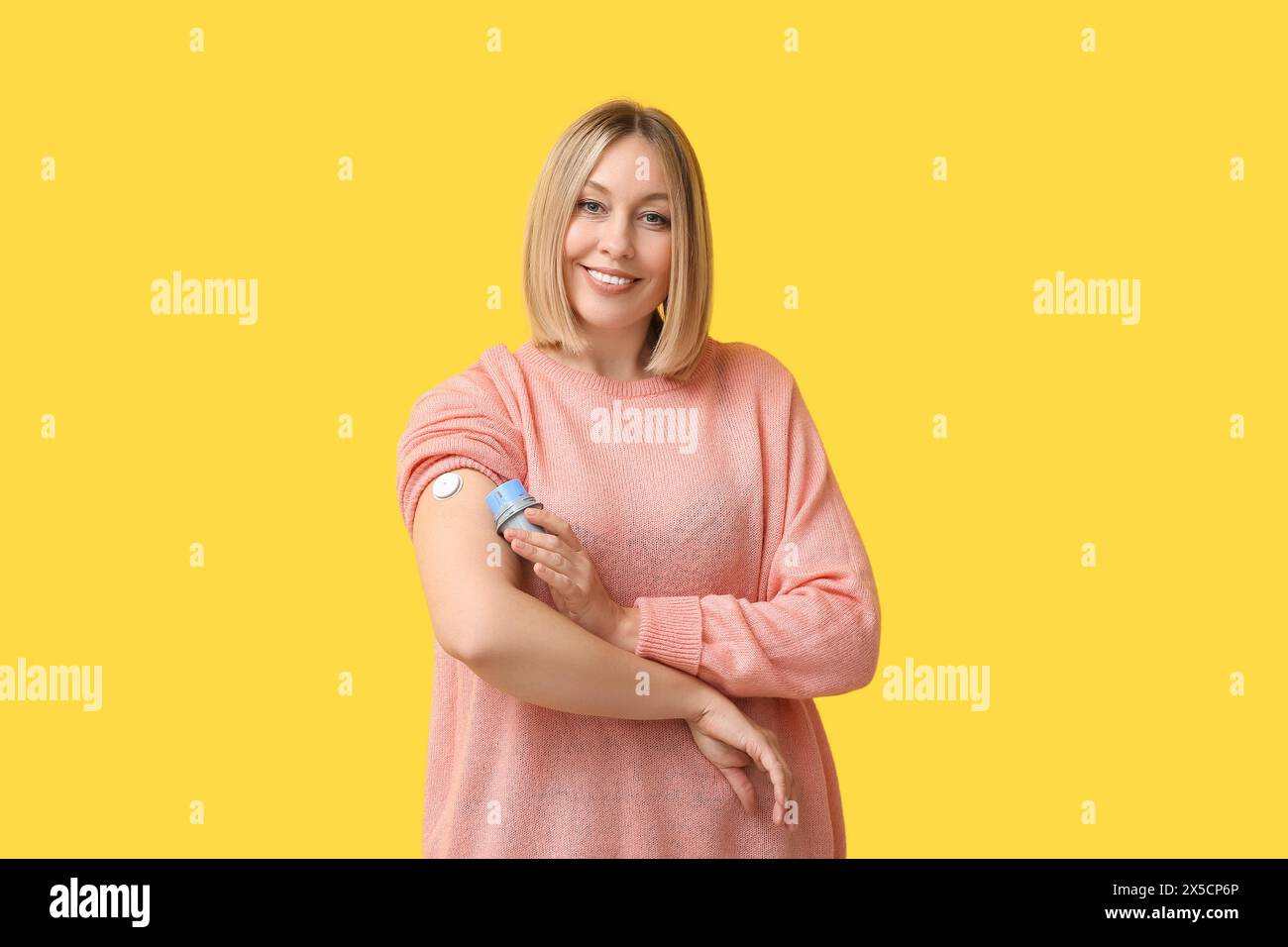 Woman with glucose sensor for measuring blood sugar level and ...