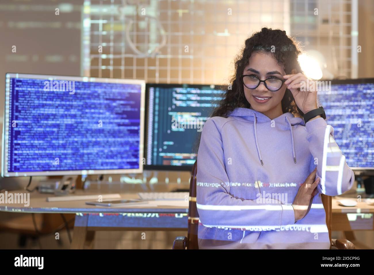 Female African-American programmer with projection of code in office at night Stock Photo - Alamy