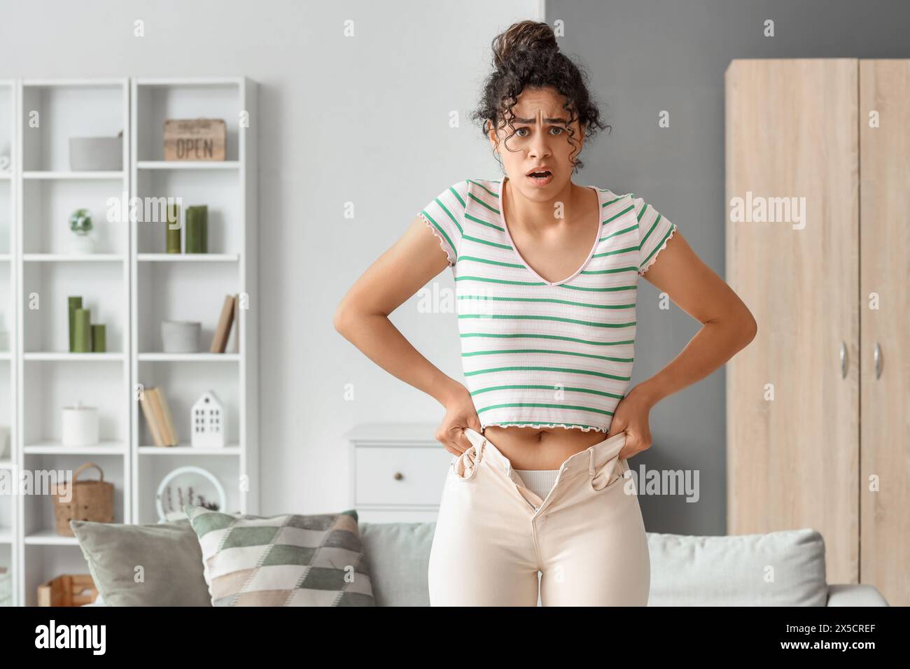Young African-American woman in tight pants at home. Diet concept Stock Photo - Alamy
