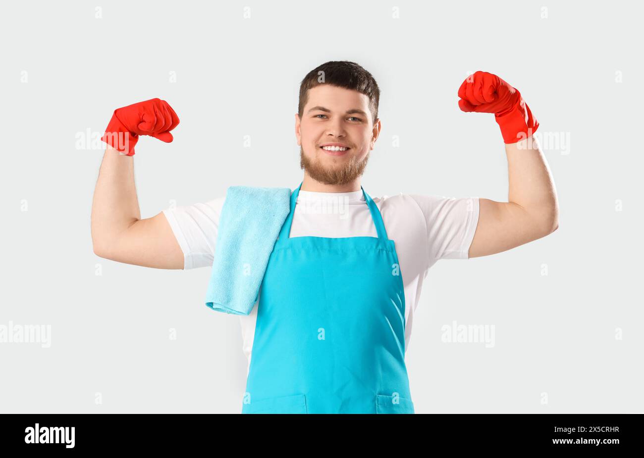 Male janitor in rubber gloves showing muscles on light background Stock ...