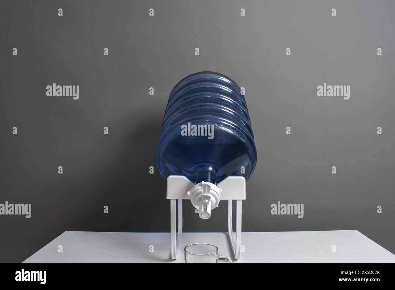 Plastic gallon on a standing shelf with a faucet isolated on gray ...