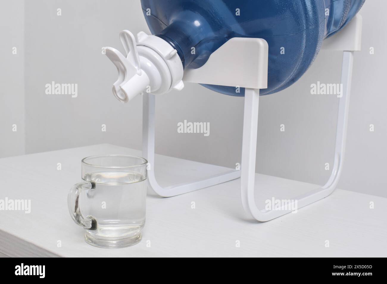 Plastic gallon on a standing shelf with a faucet isolated on white ...