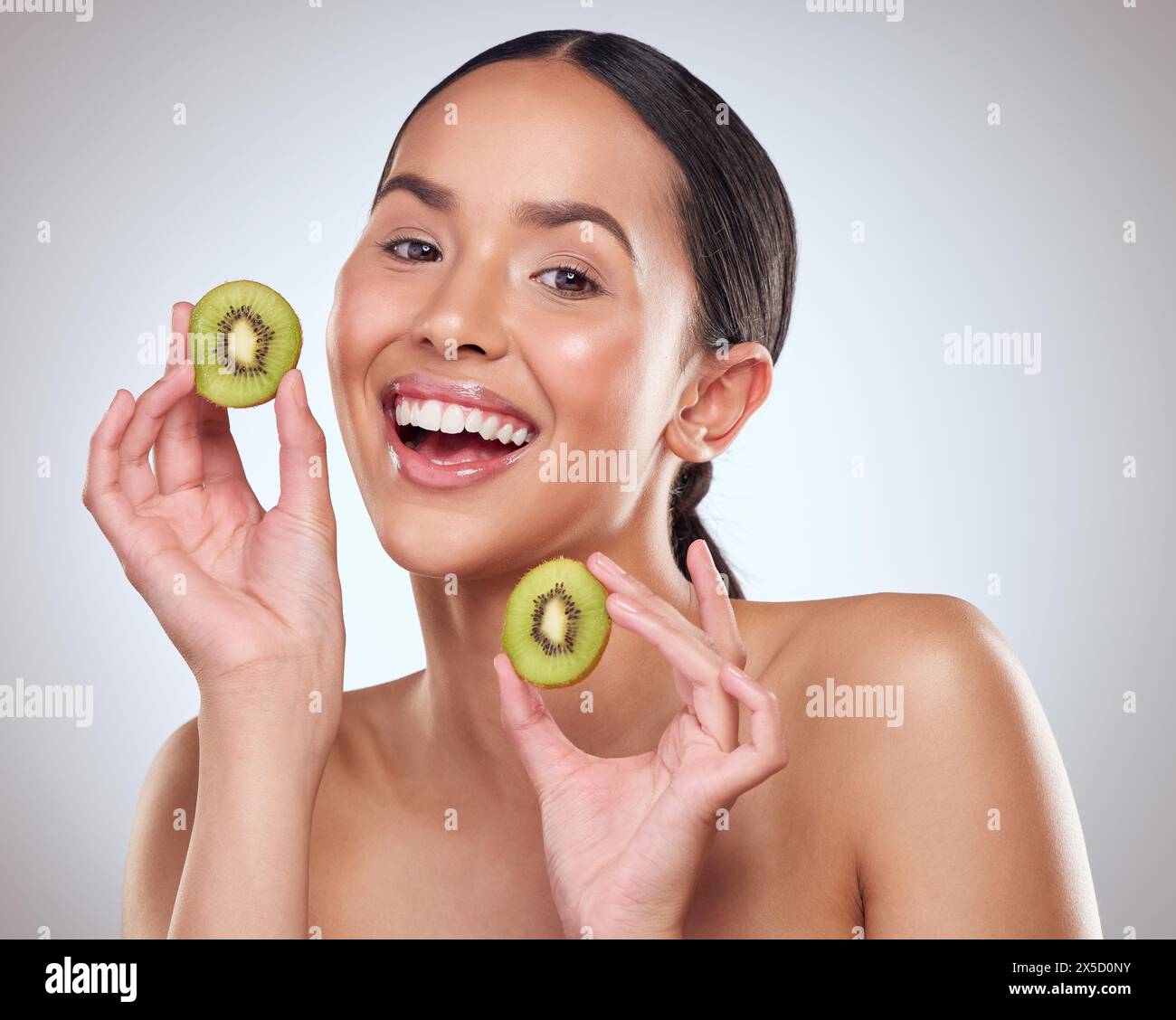 Beauty, kiwi and smile with portrait of woman in studio on gray ...