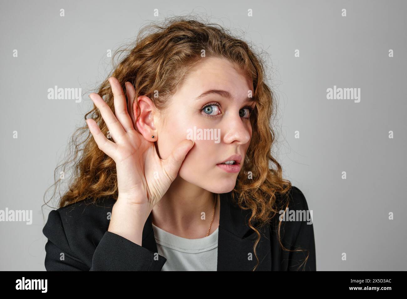 Young Woman Listening With Hand to Ear Stock Photo - Alamy