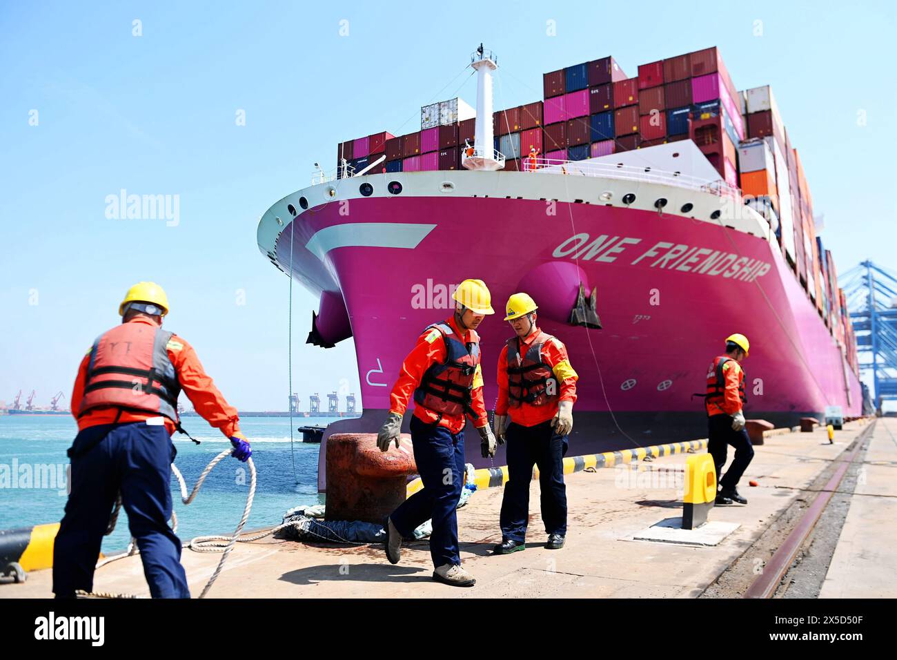 QINGDAO, CHINA - MAY 9, 2024 - Dockworkers bring cables to a berthing ...