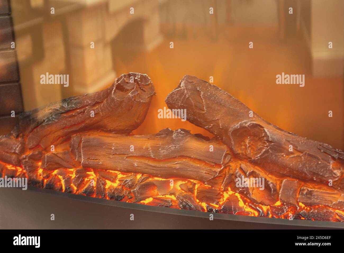 The logs of the fireplace burn with a bright fire. Artificial ...