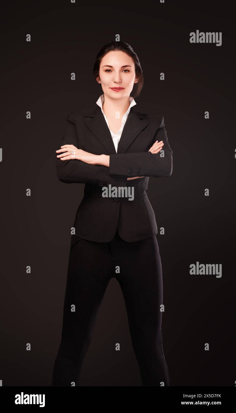 Professional young woman dressed in a sharp black suit, standing ...