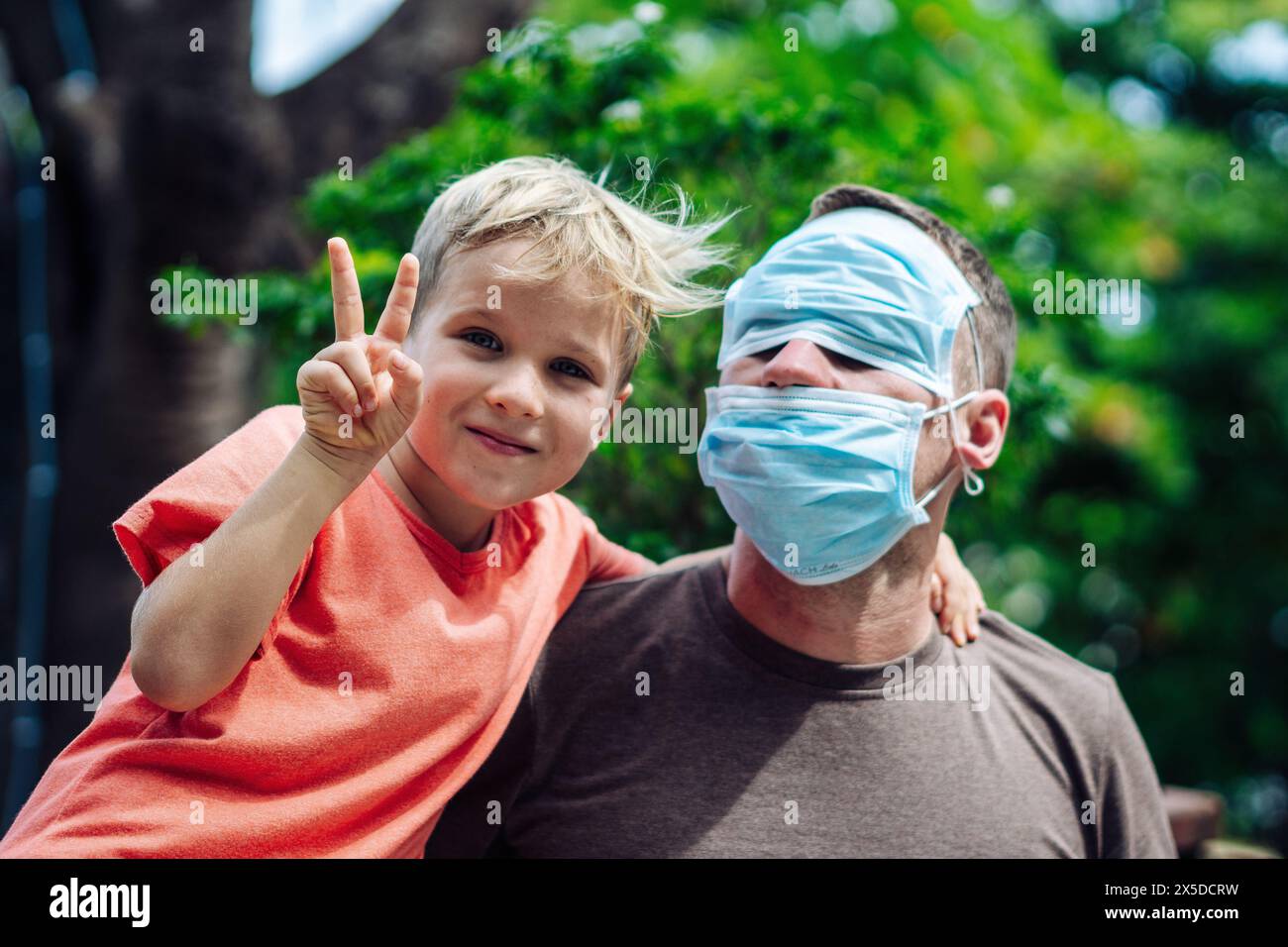 Father and little son hugging, making faces, show a tongue, open mouth ...
