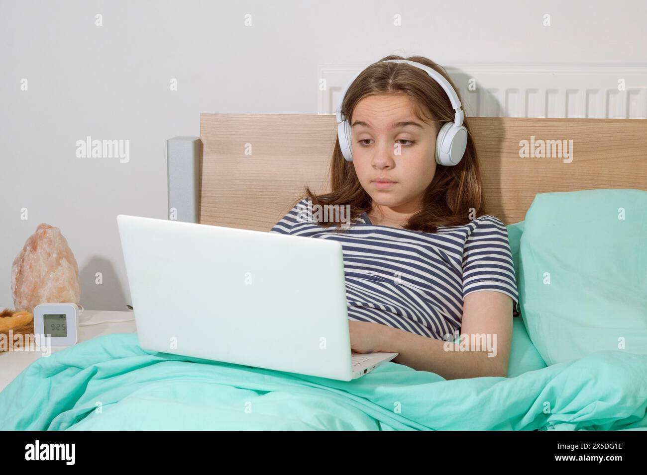 A teen girl is going to sleep tired of the computer in bed. Computer in ...