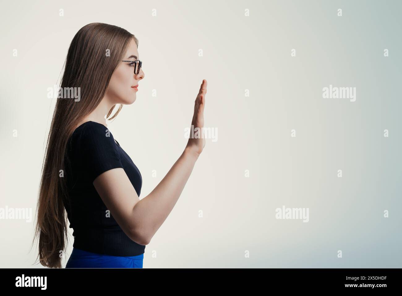 Woman's raised hand might imply greeting, stopping action, or ...