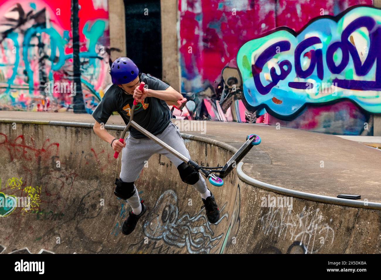 A youth in green shirt with blue helmet does tricks at the Wilderness ...