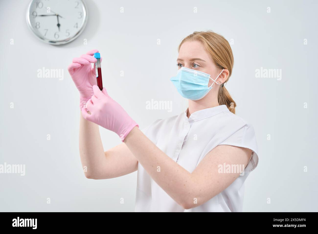 Qualified woman laboratory worker checking the vacutainer with blood ...