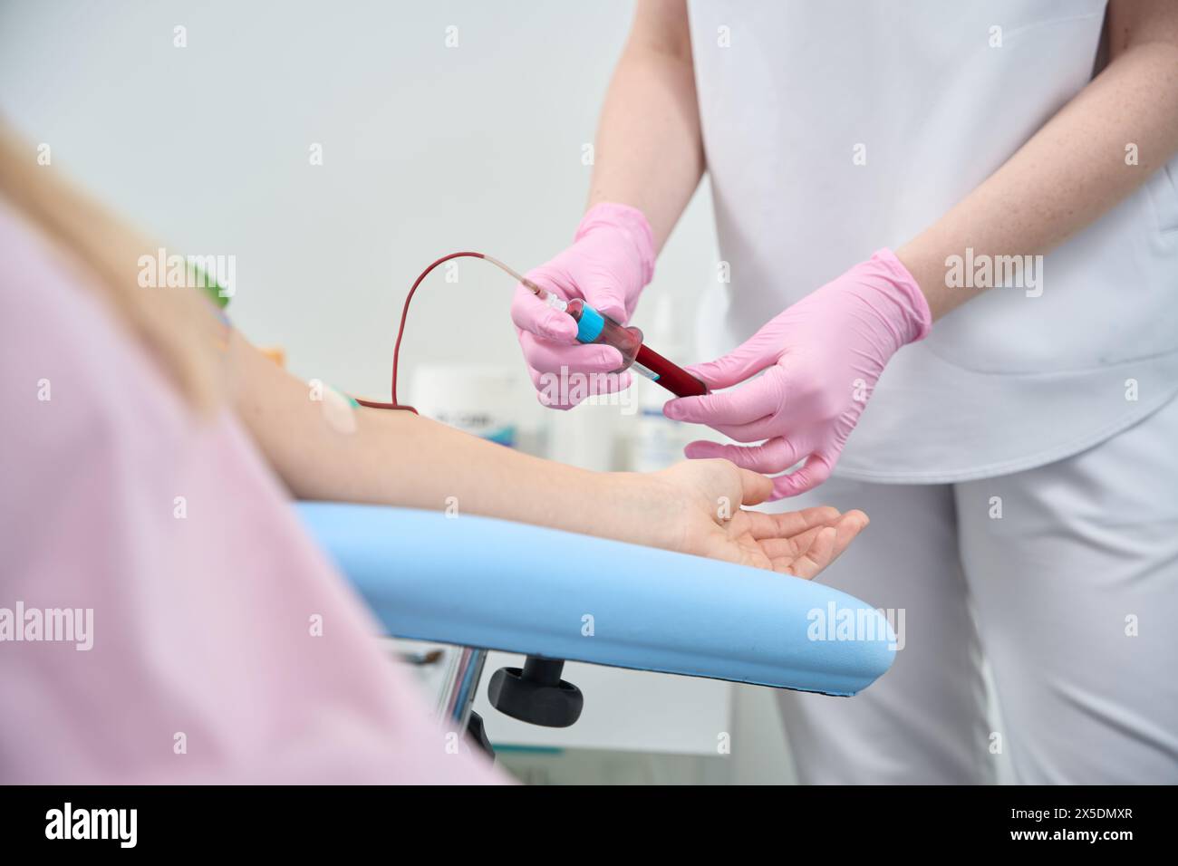 Woman receiving medication through intravenous line sitting in medical clinic Stock Photo - Alamy