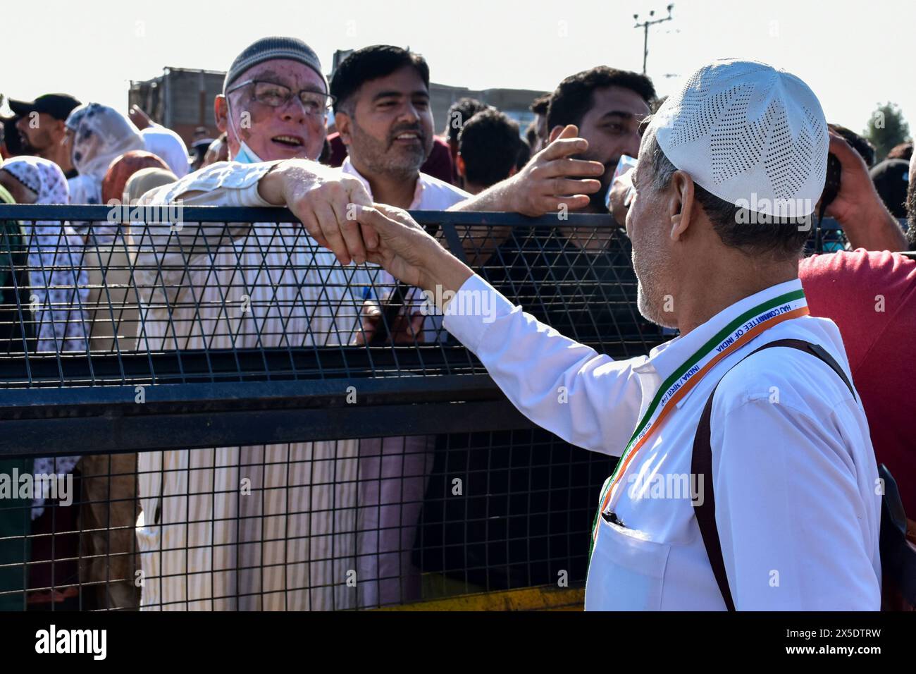 Srinagar, India. 09th May, 2024. A Kashmiri Muslim pilgrim (R) holds a ...