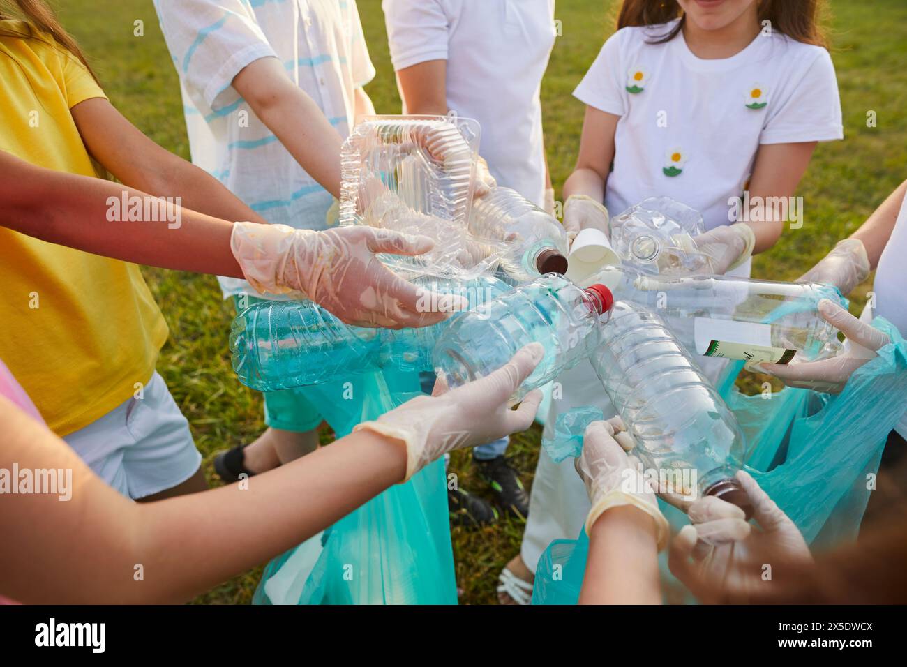 Variety of plastic containers are in hands of children who clean up ...