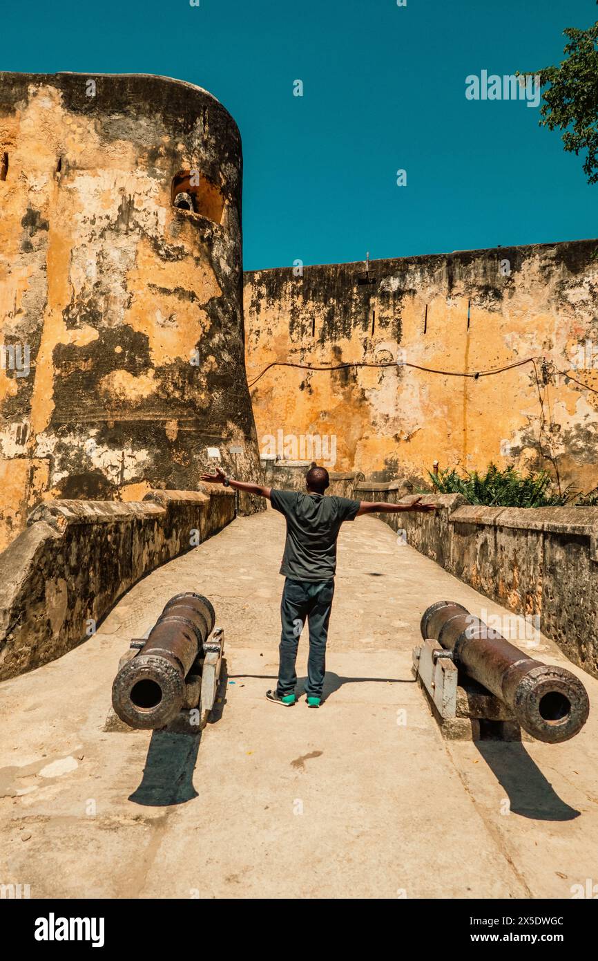 Rear view of a man standing between two cannons at the entrance of Fort ...