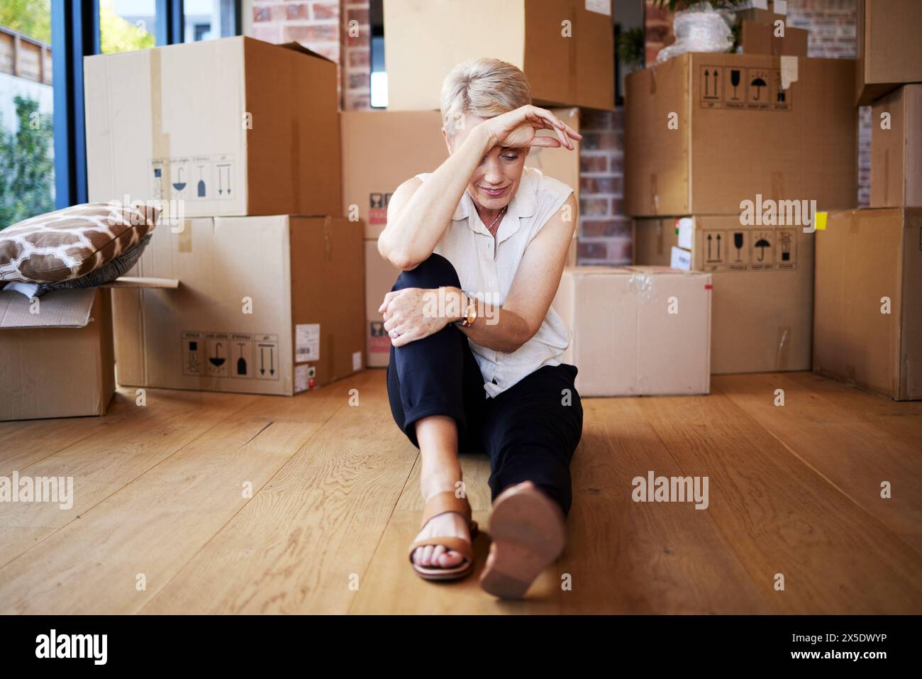 Mature woman, tired and boxes in new home, burnout and exhausted on ...