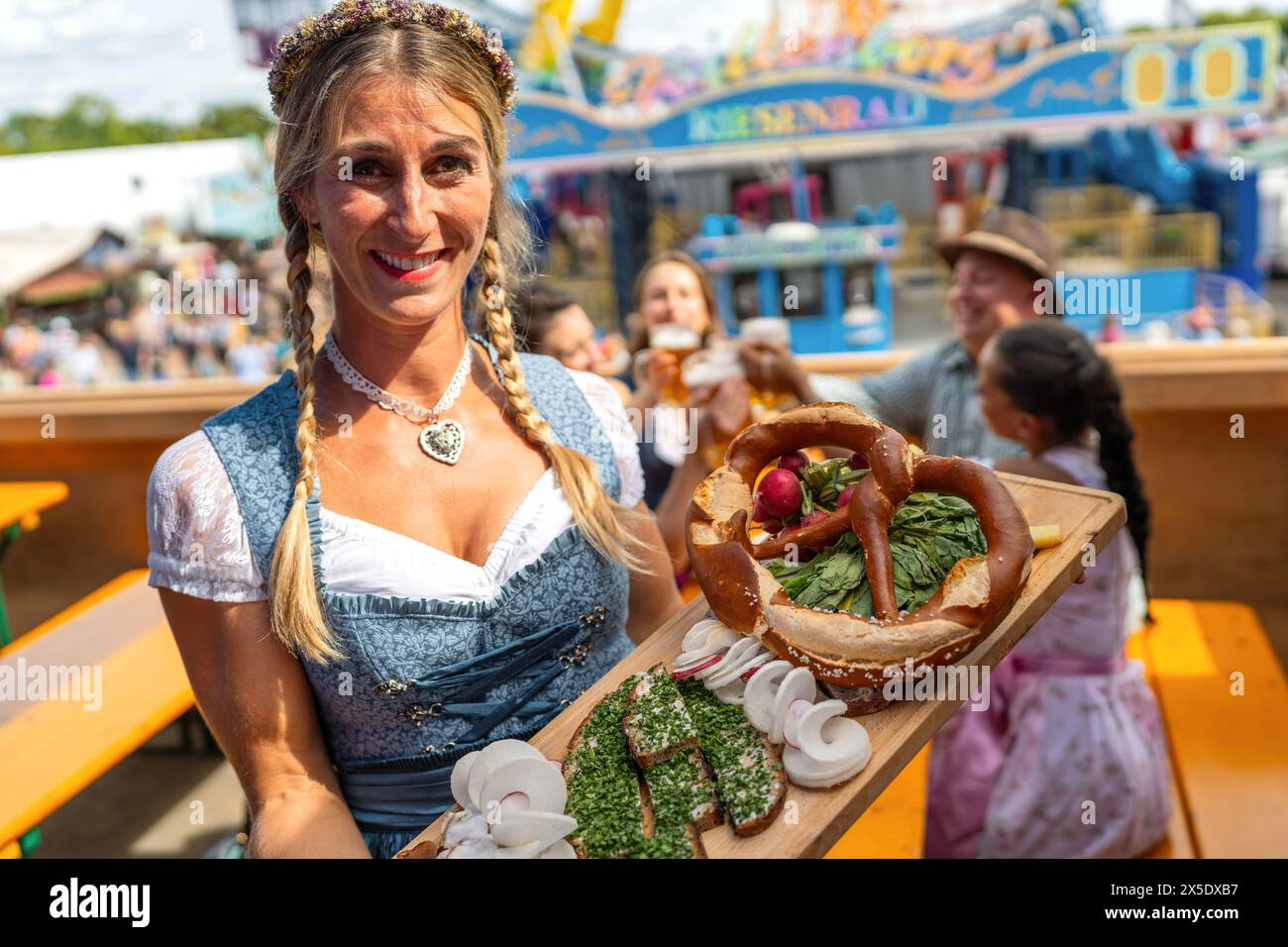 Smiling Waitress in traditional Bavarian dress or dirndl holding a ...