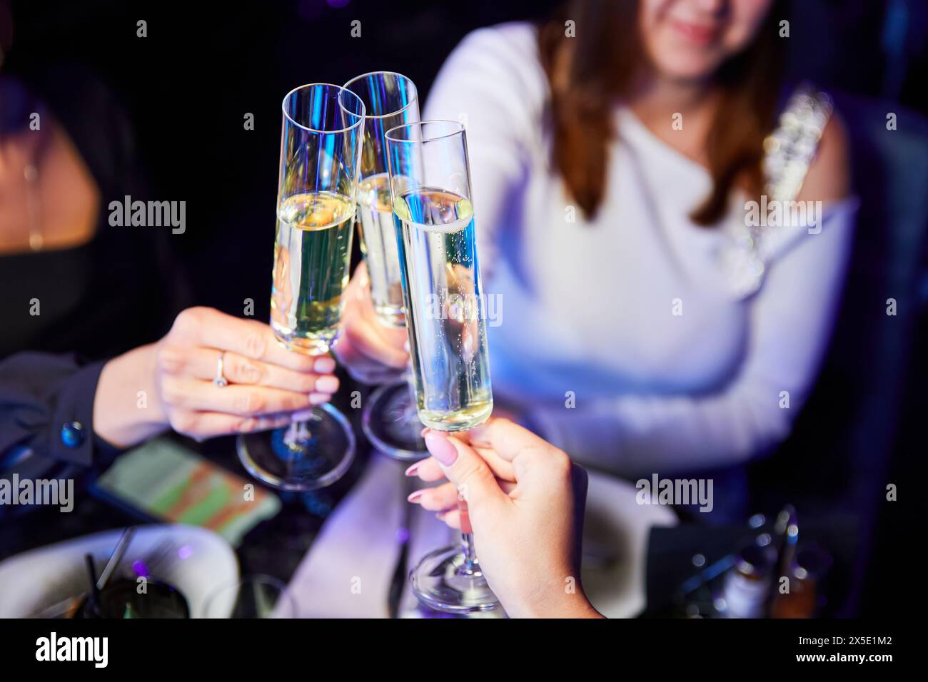 Girls in a nightclub clink glasses with alcoholic drinks Stock Photo ...