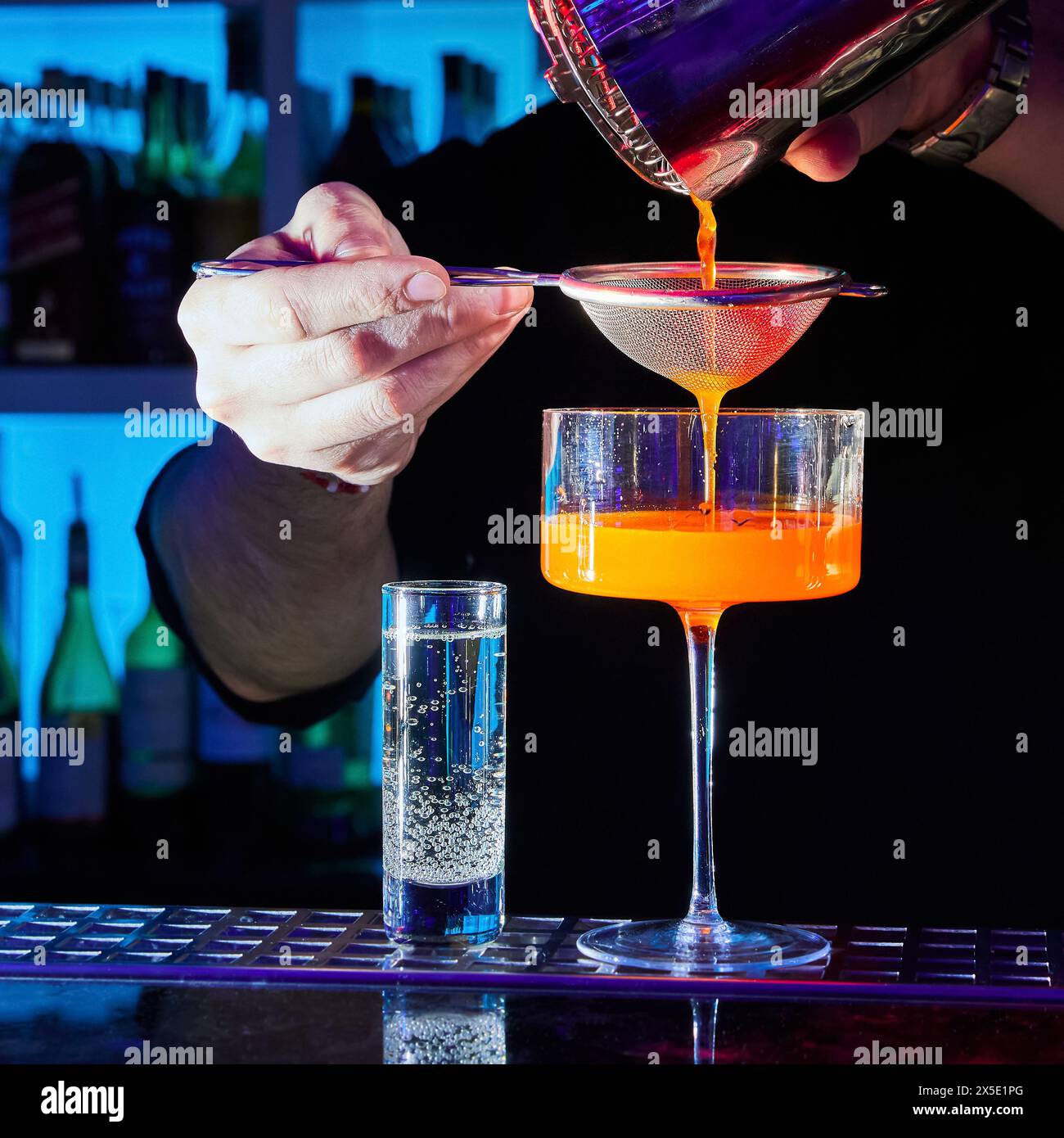 The bartender prepares a cocktail Is Love on the bar counter using a ...
