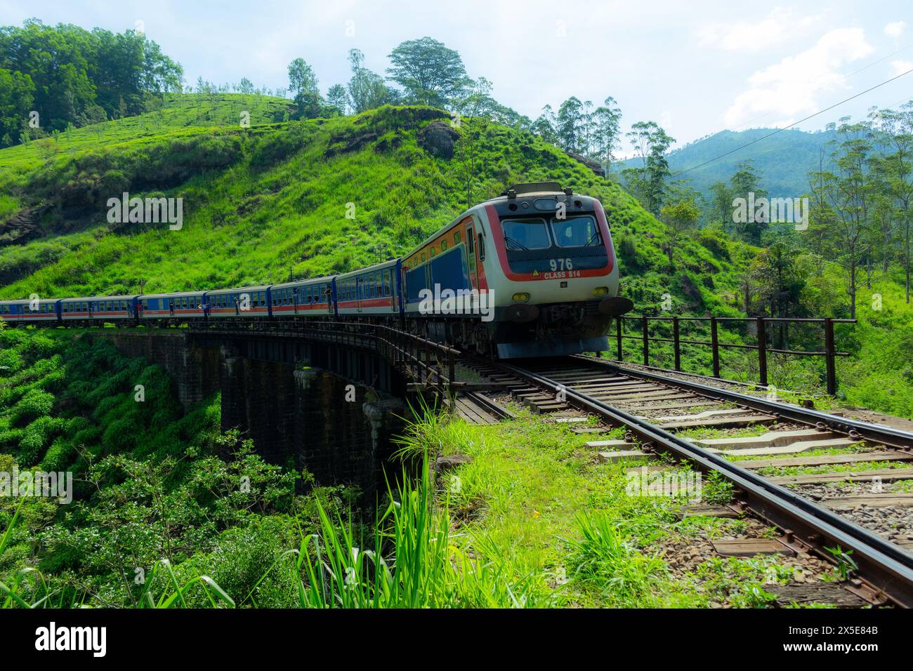 Traversing Ella's iconic demodara Bridge, a train weaves through lush ...
