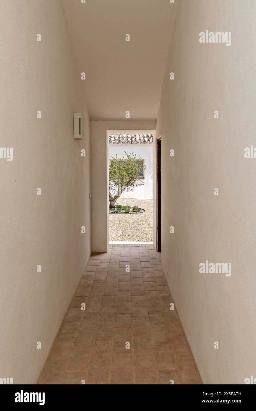 Interior passageway with smooth walls and terracotta floors overlooking ...