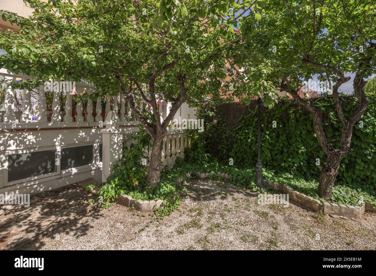 a patio with white gravel floors with white cement balustrade on stairs ...