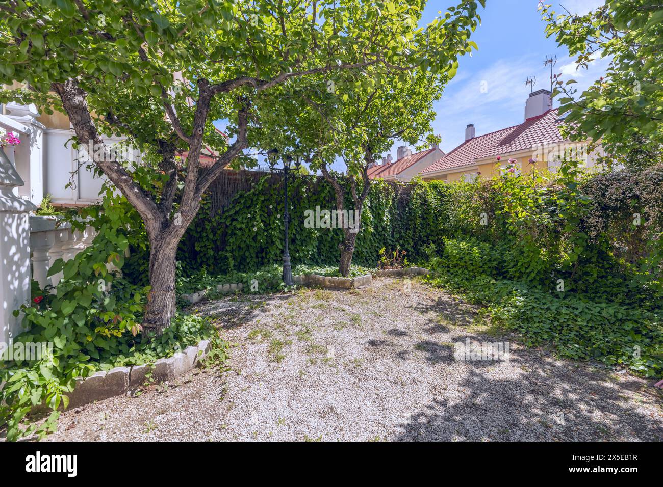 a patio with white gravel floors with white cement balustrade on stairs ...